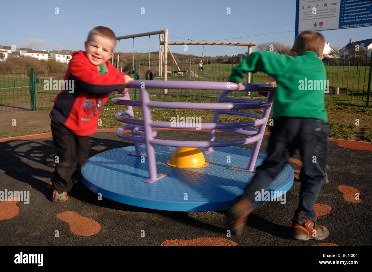 Playing on roundabout children's play area Broad Haven Pembrokeshire ...