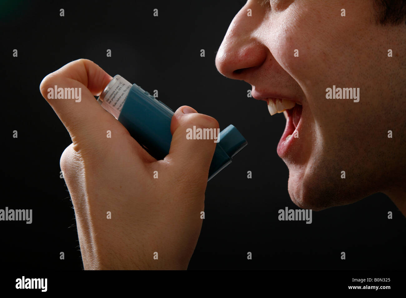 Close up of a man using an inhaler to treat his asthma Stock Photo - Alamy