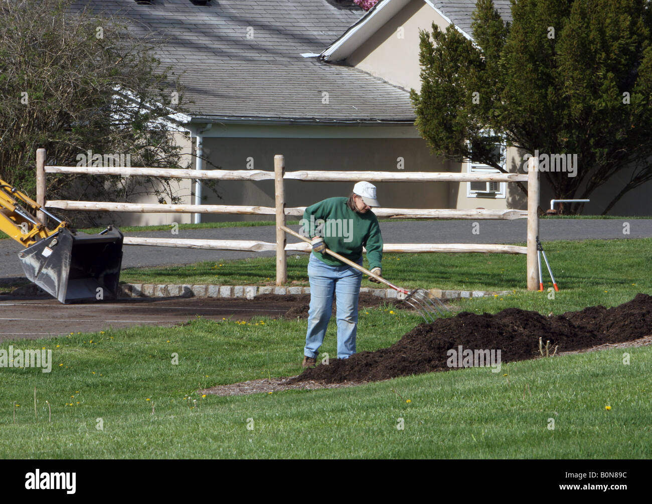 A gardener raking mulch Stock Photo - Alamy