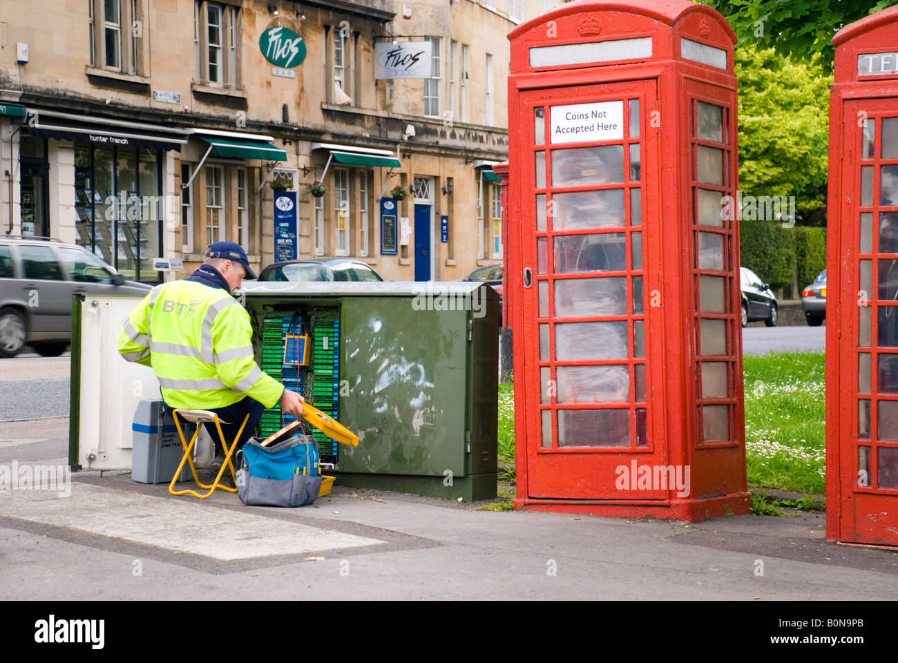 British Telecom engineer at work on a junction box in the city next to ...