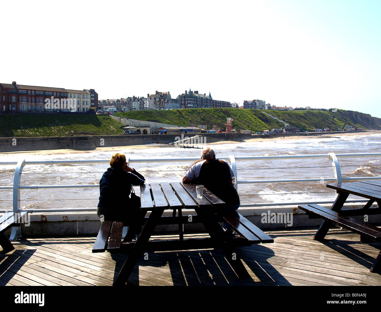 two people enjoying the view of the north promenade from the pier at ...