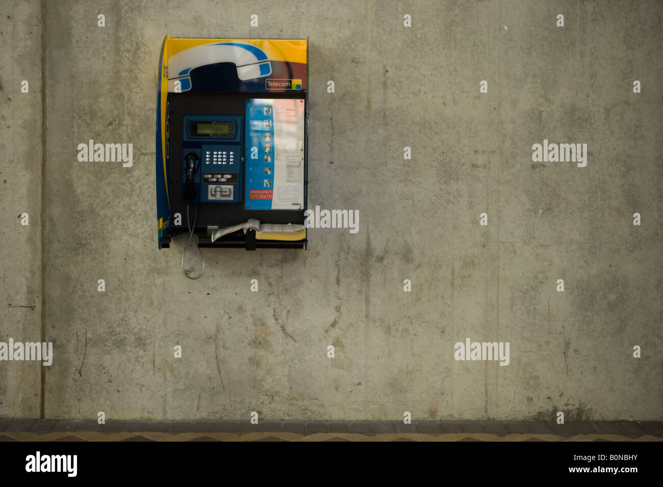 Telephone and directory on concrete wall Stock Photo - Alamy