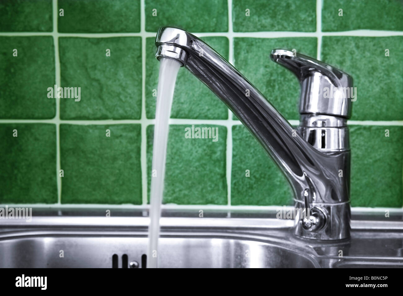 Kitchen water tap and green tiles Stock Photo - Alamy