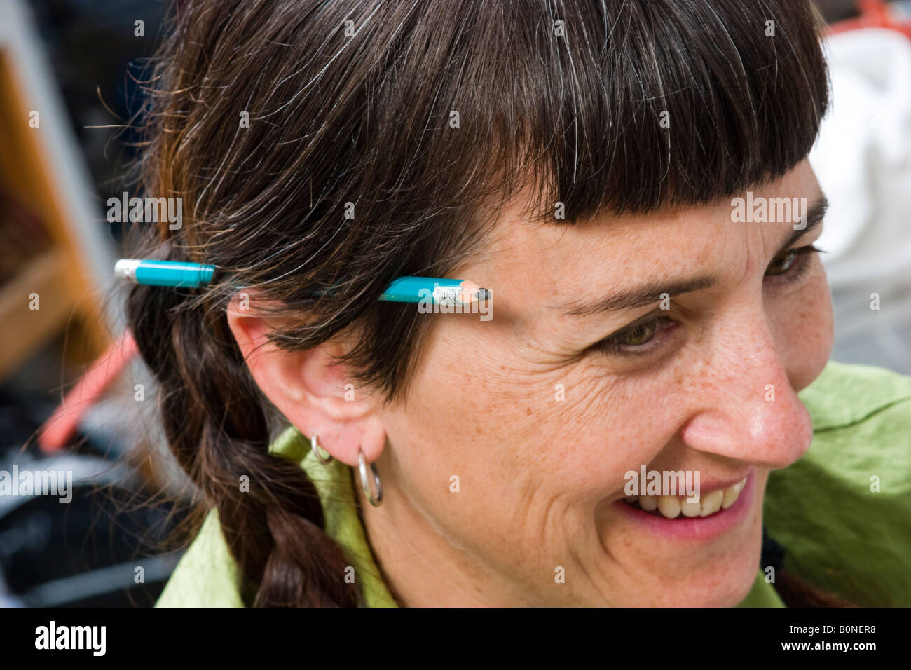Close up of a young woman with a pencil being held by her ear MODEL ...