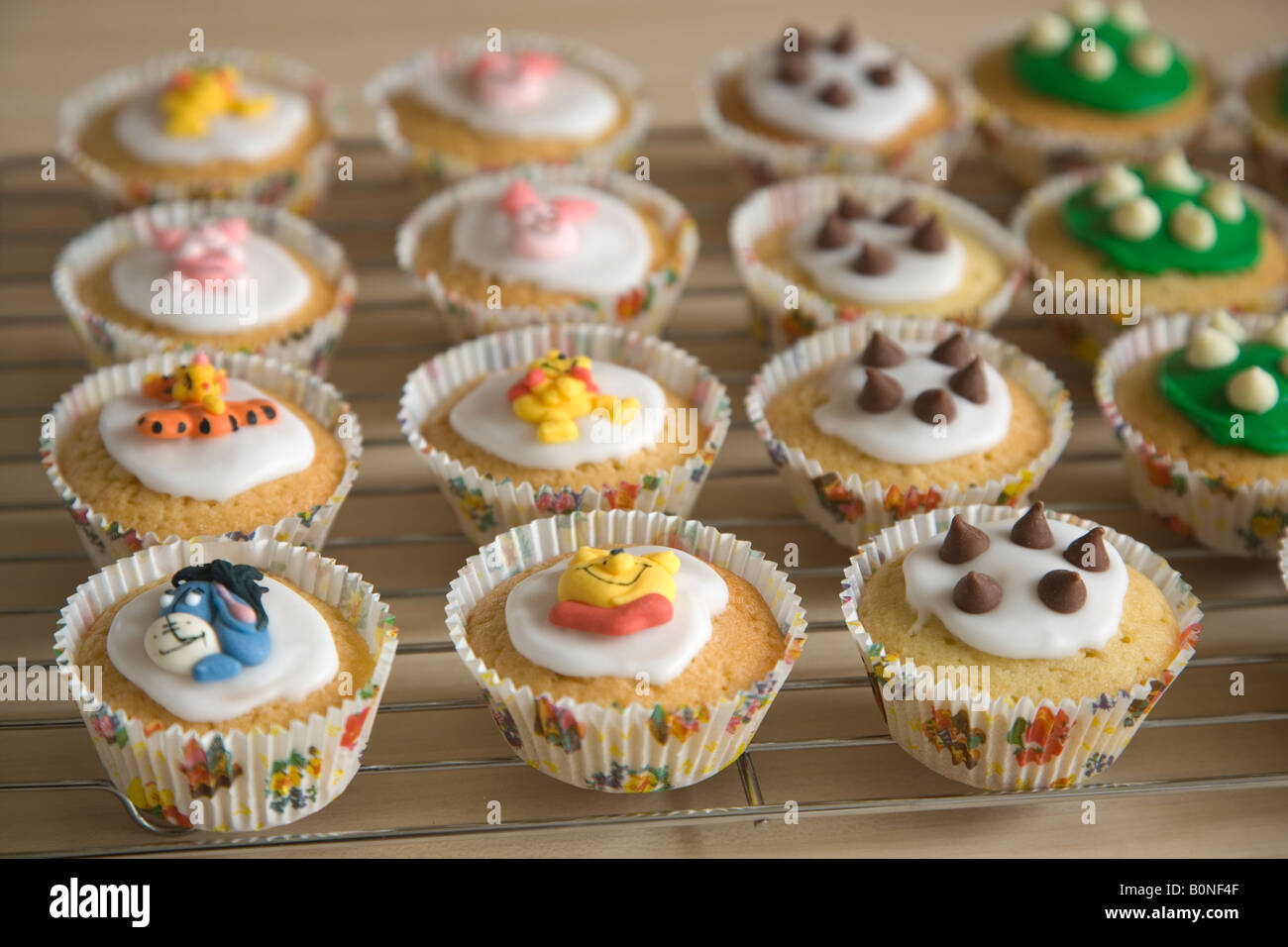 Colourful iced cupcakes on a wire rack on a kitchen worktop Stock Photo ...