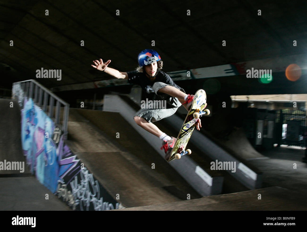 Young man, boy skateboarding, jumping over skateboard ramp Stock Photo ...