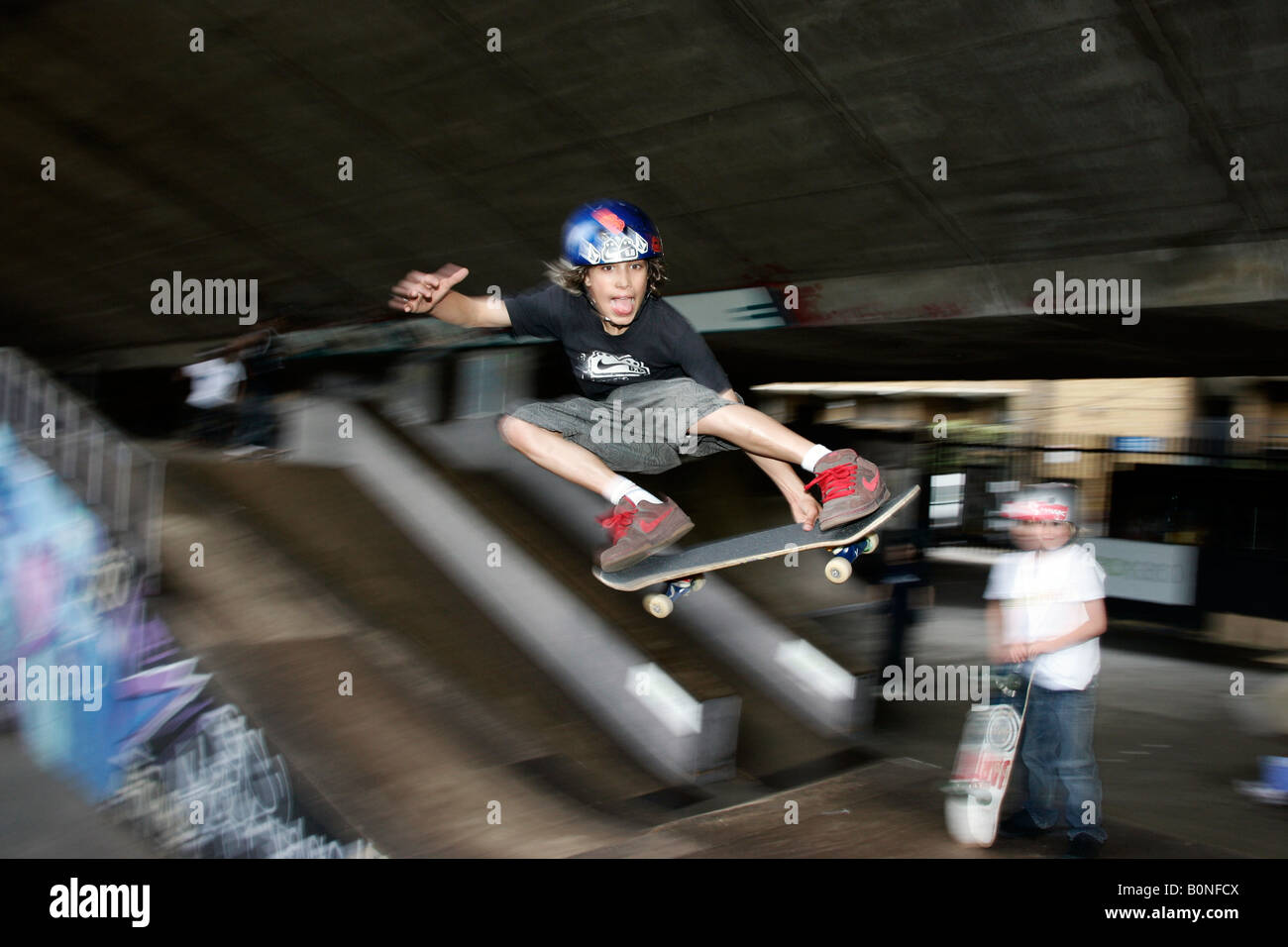Young man skateboarding, jumping over skateboard ramp Stock Photo - Alamy