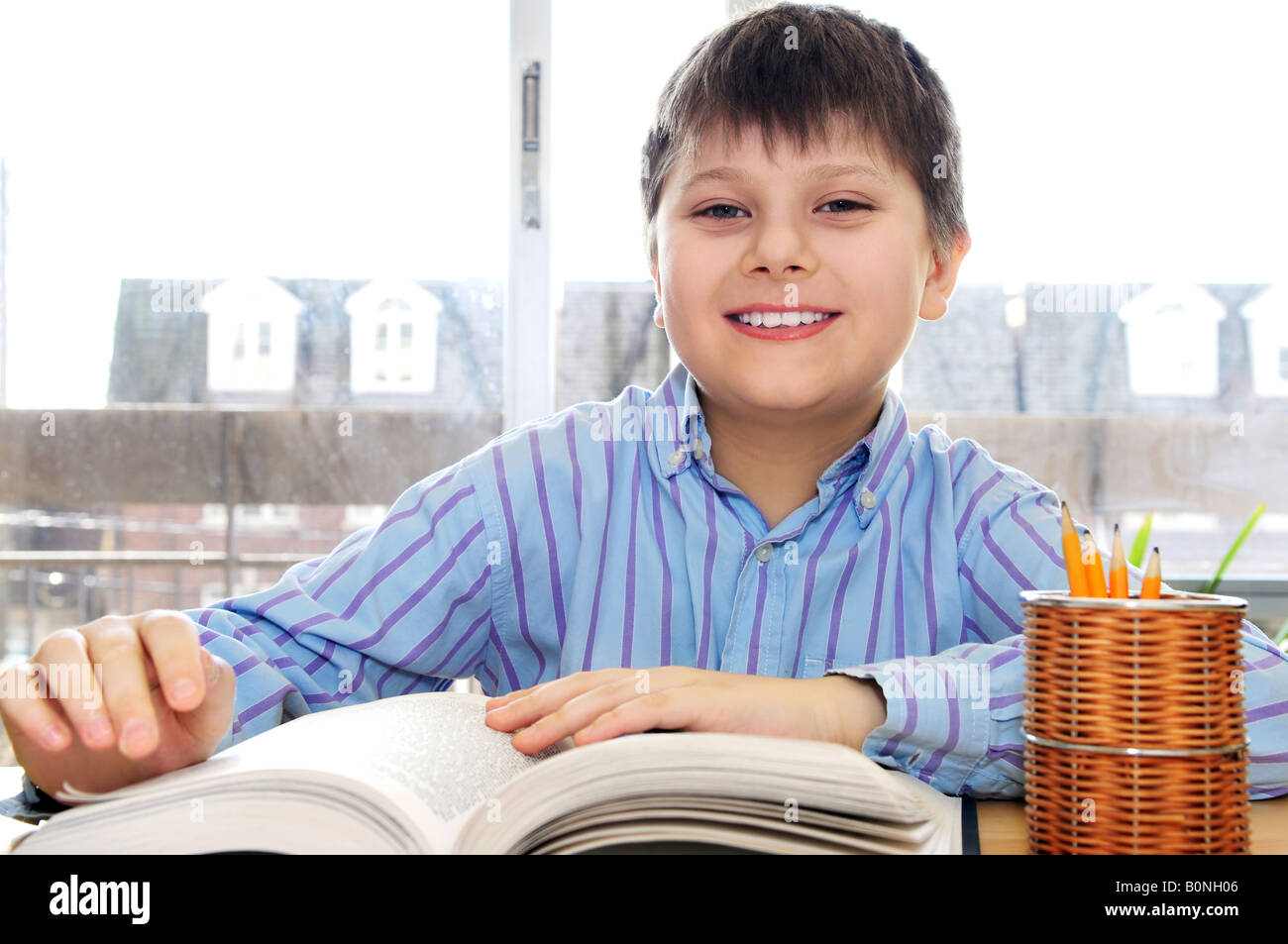 Happy school boy studying with a book Stock Photo - Alamy