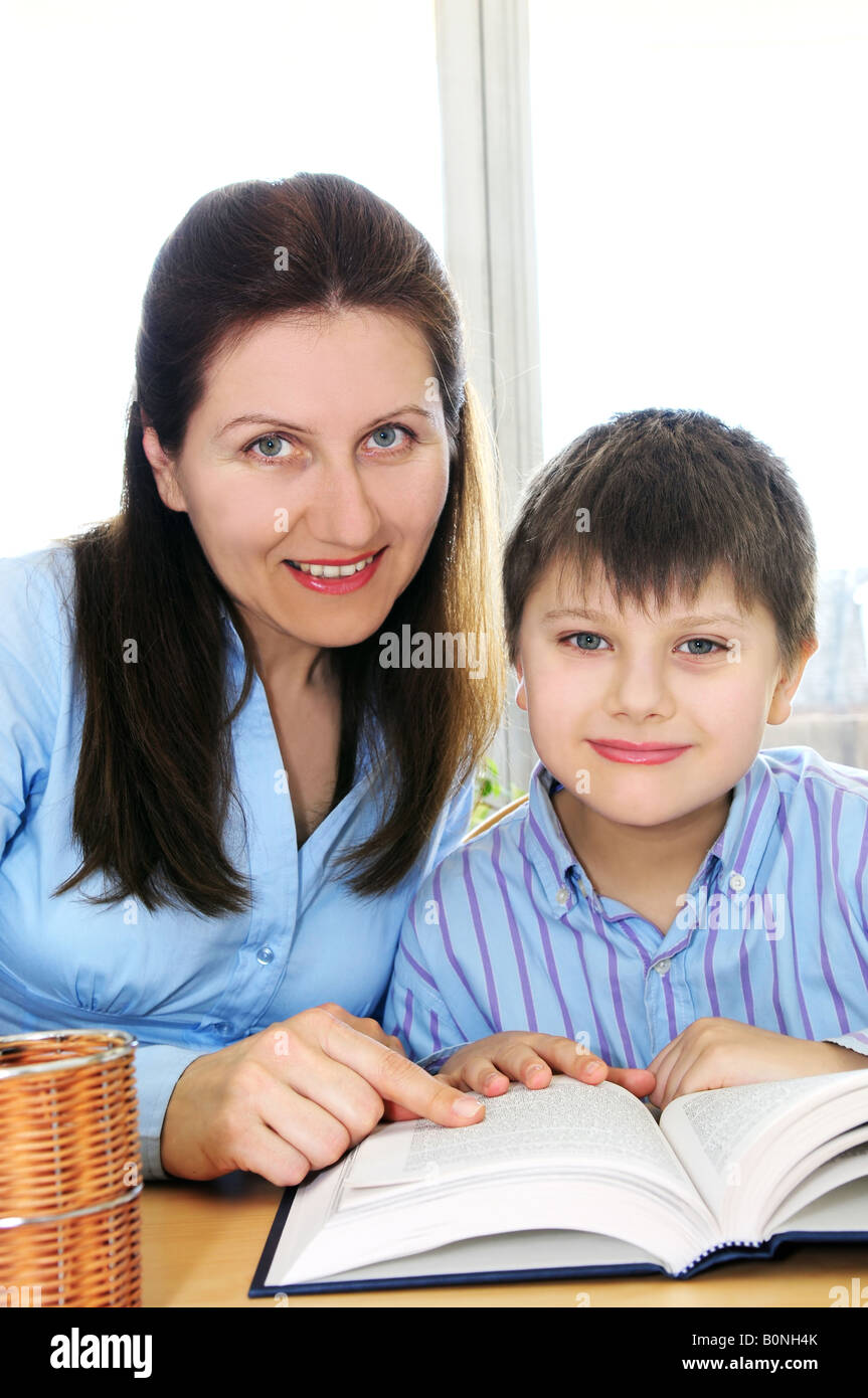 Teacher or tutor helping school boy to study Stock Photo - Alamy