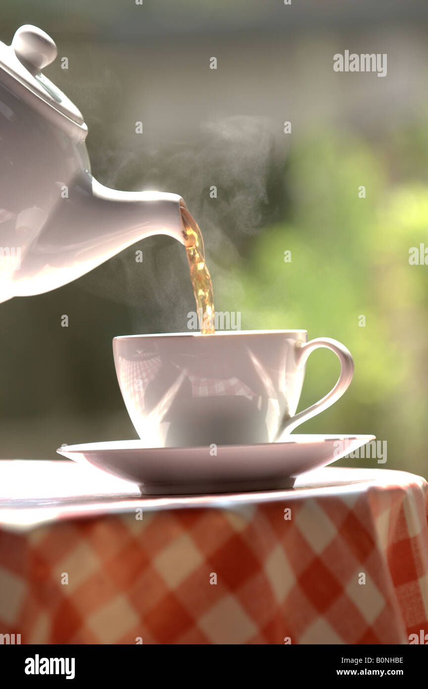 Pouring tea in the garden Stock Photo - Alamy