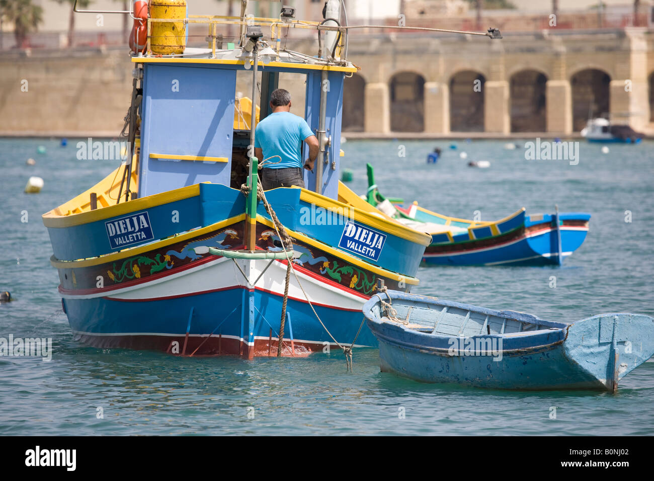 Traditional Maltese fishing boat; Fisherman repainting a Luzzu Eye of ...