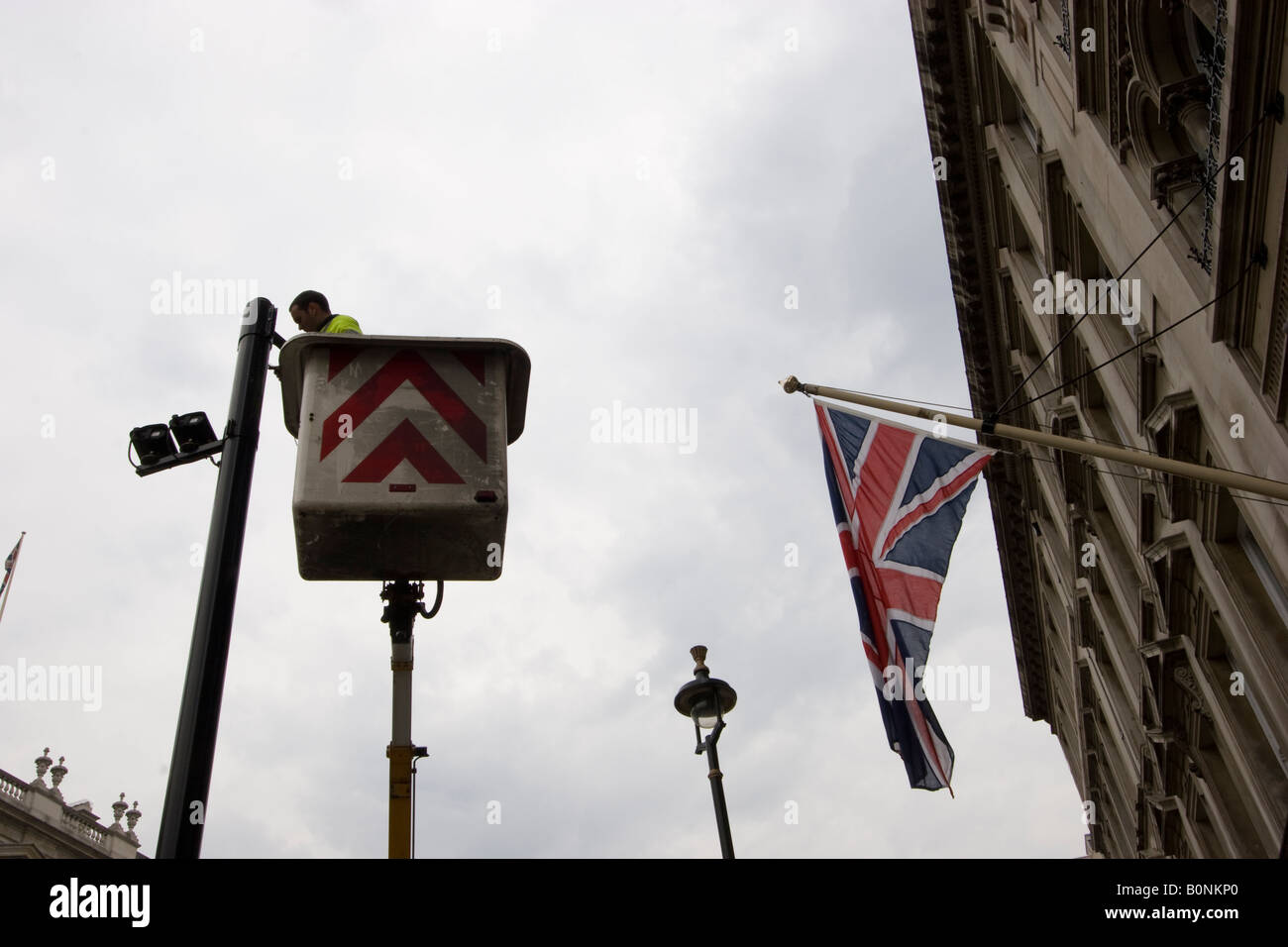 workman in cherry picker maintaining cctv close circuit television ...