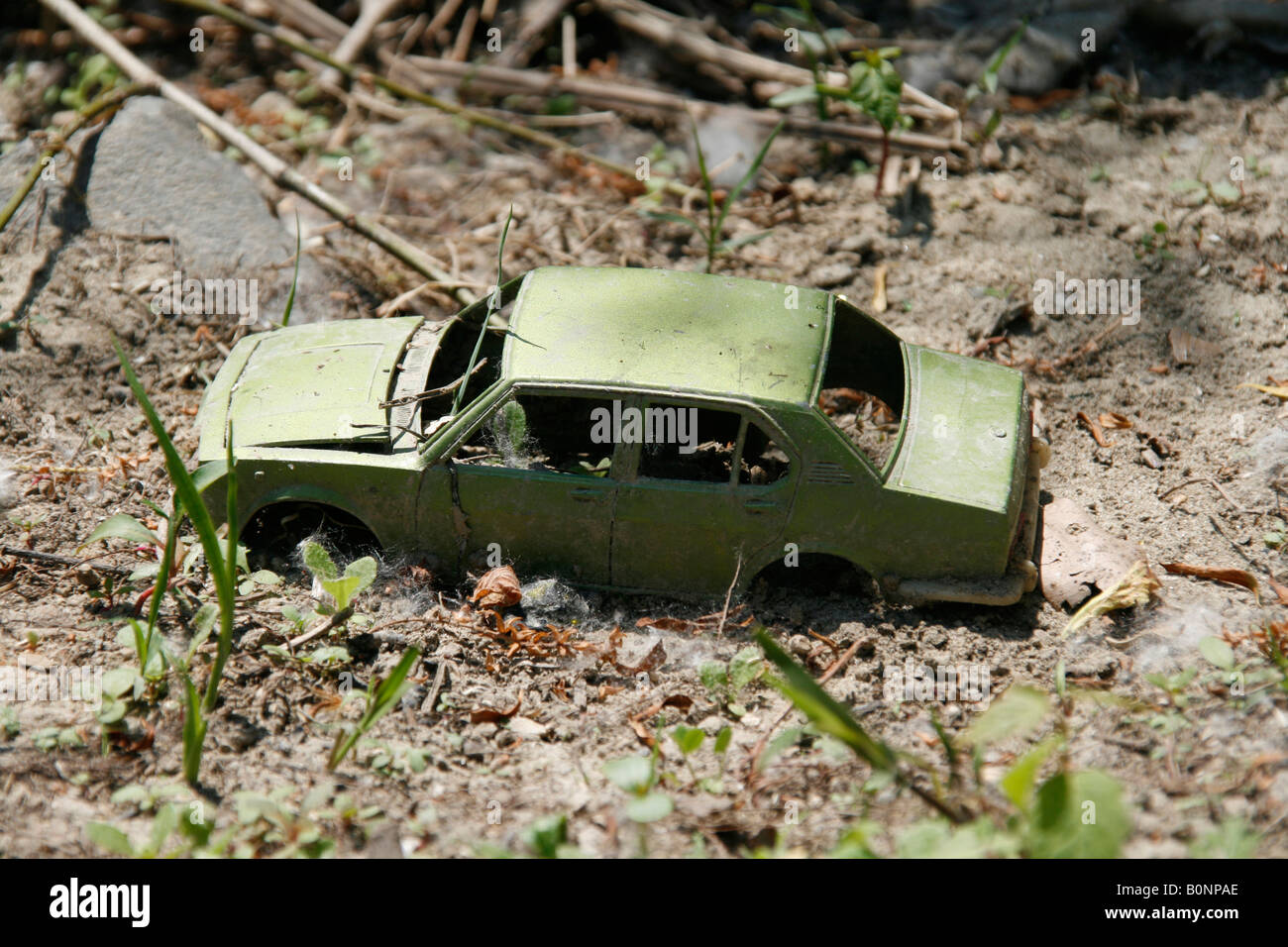 old damaged green toy car in field Stock Photo - Alamy