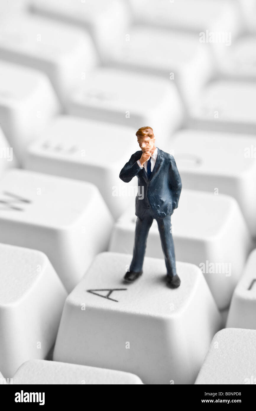 Businessman figurine standing on a computer keyboard Stock Photo - Alamy
