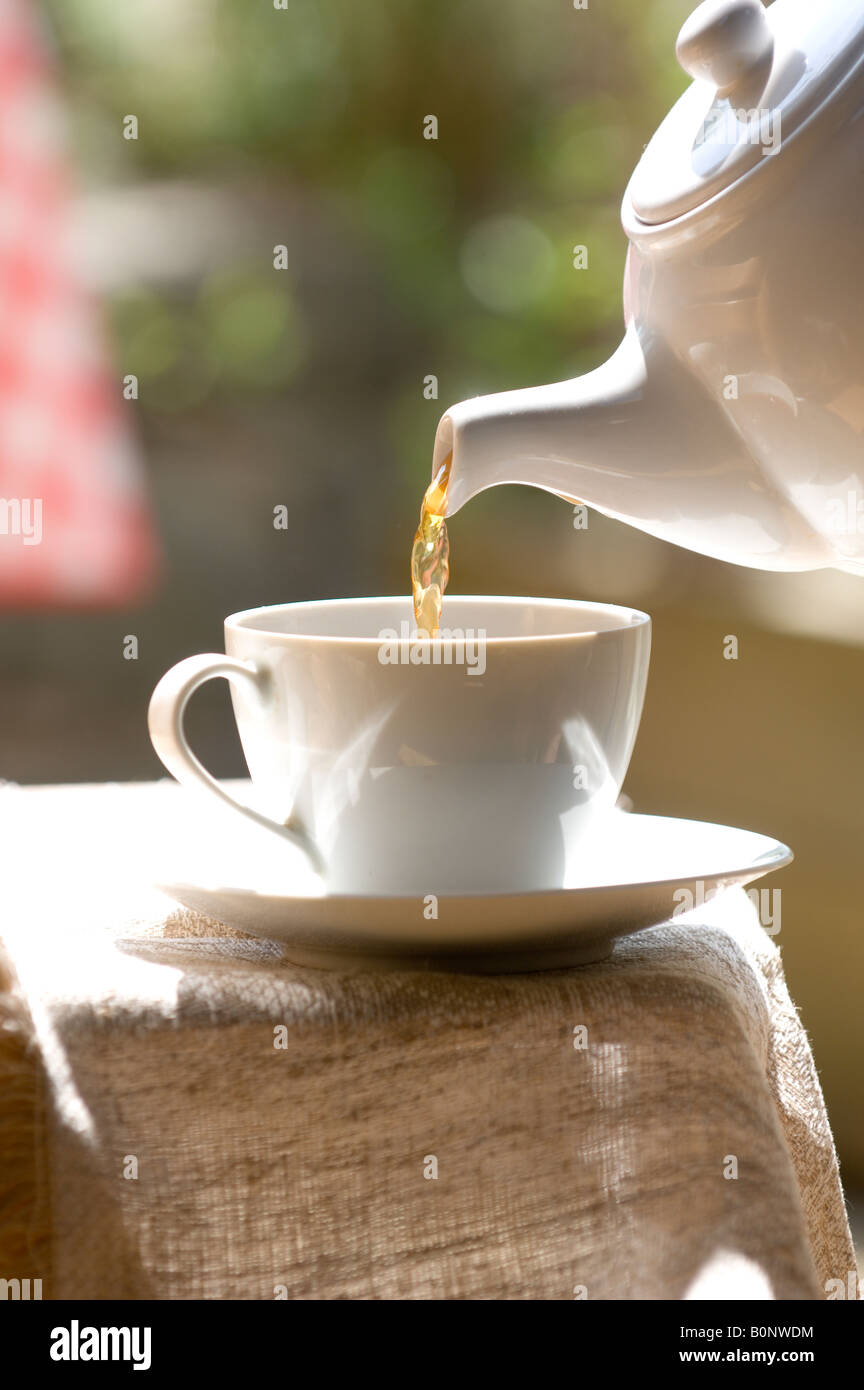 Pouring tea in the garden Stock Photo - Alamy
