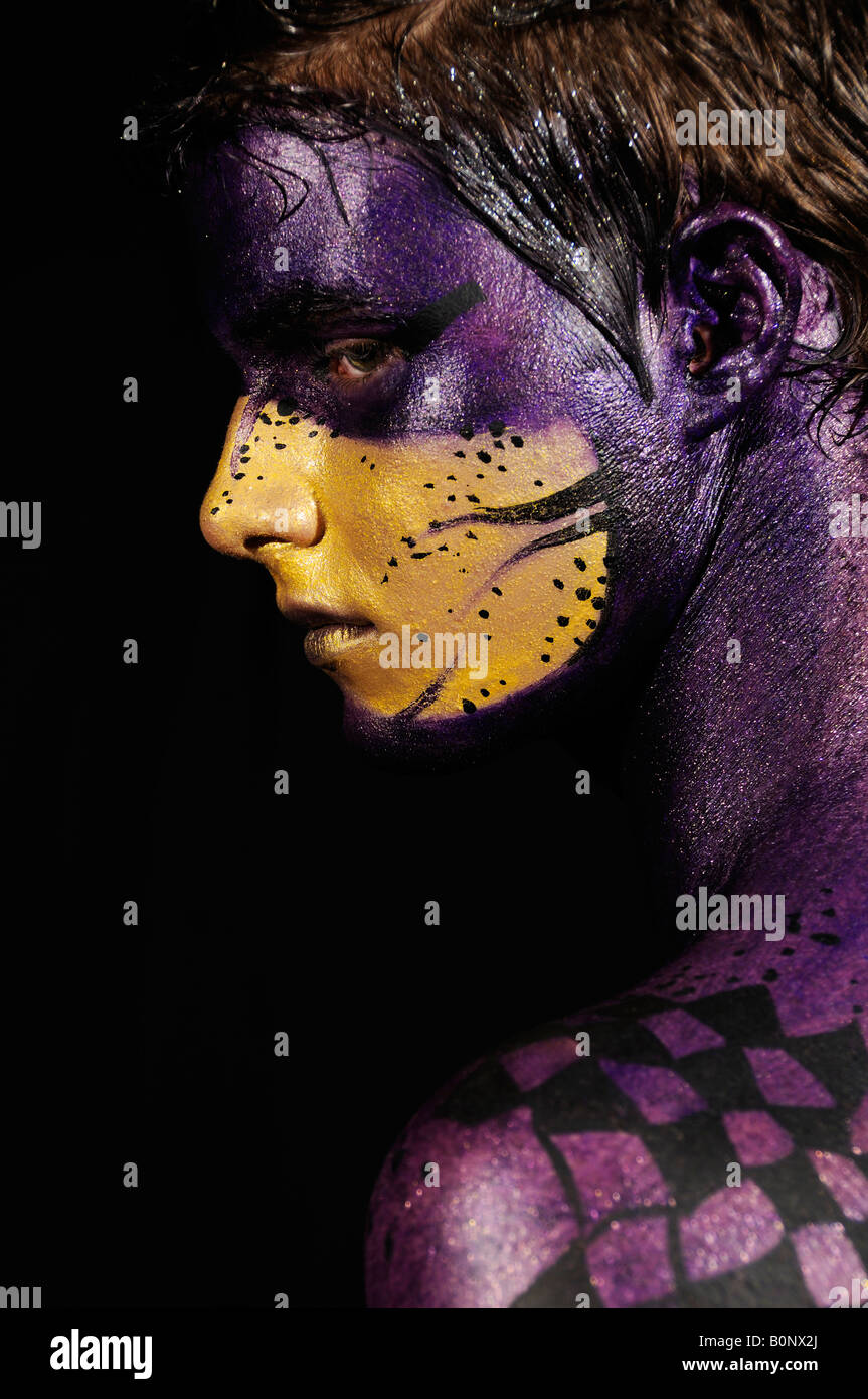 Portrait of young handsome male model wearing artistic bodypaint ...