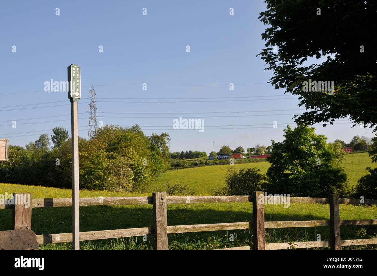 A public footpath crossing fields in the countryside with trees and ...