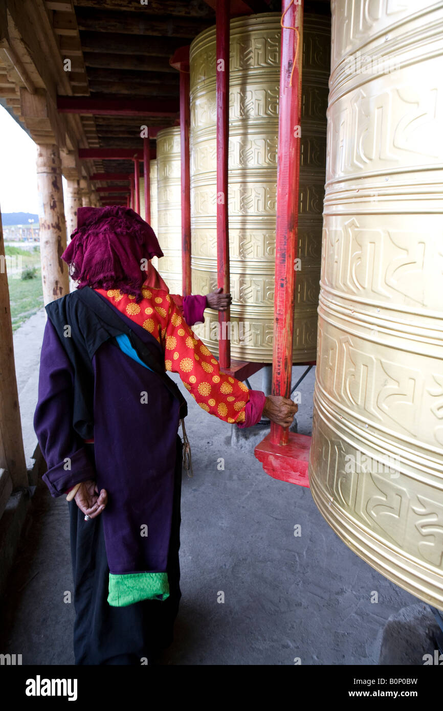 Elderly Tibetan women turning big prayer wheels in Buddhist monastery ...