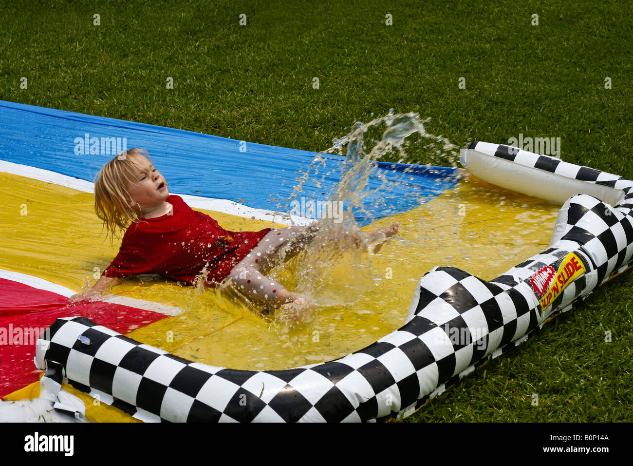 Girl sliding on slip n slide Stock Photo - Alamy