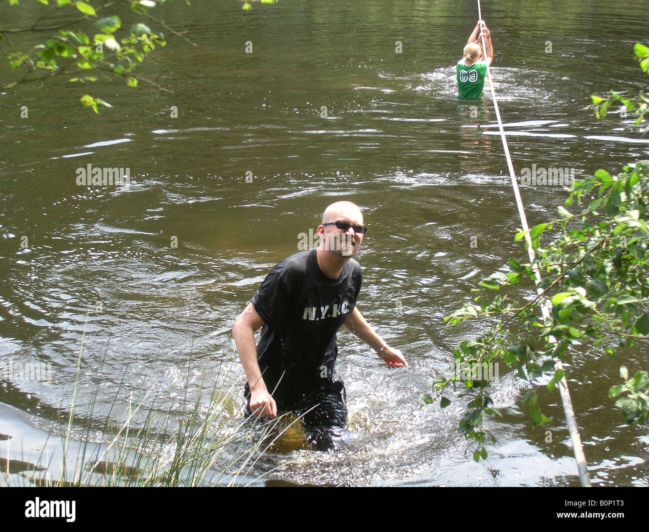 student crossing falling in river from rope ladder Stock Photo - Alamy