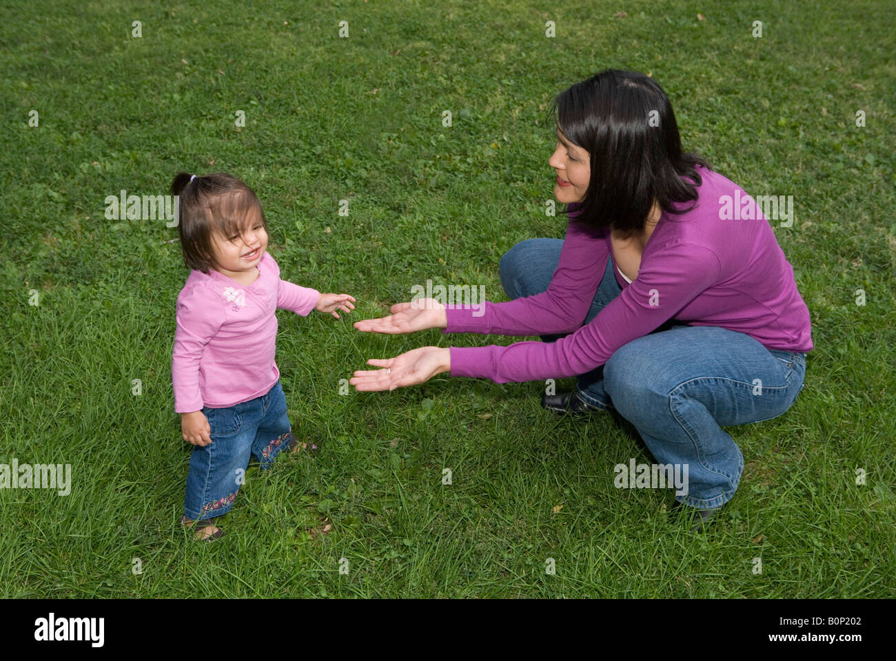 native american navajo mother holding her arms out to toddler daughter ...