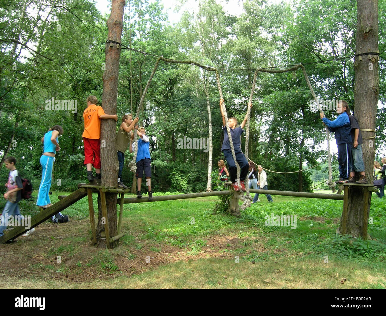 students walking over climbing ropes at school camp Stock Photo - Alamy
