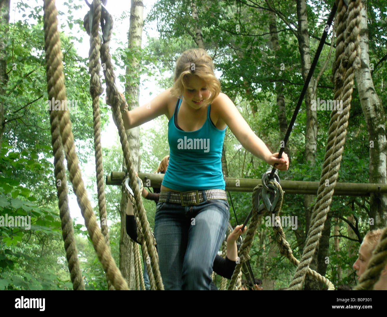 girl student holding on to climbing ropes at school camp Stock Photo ...
