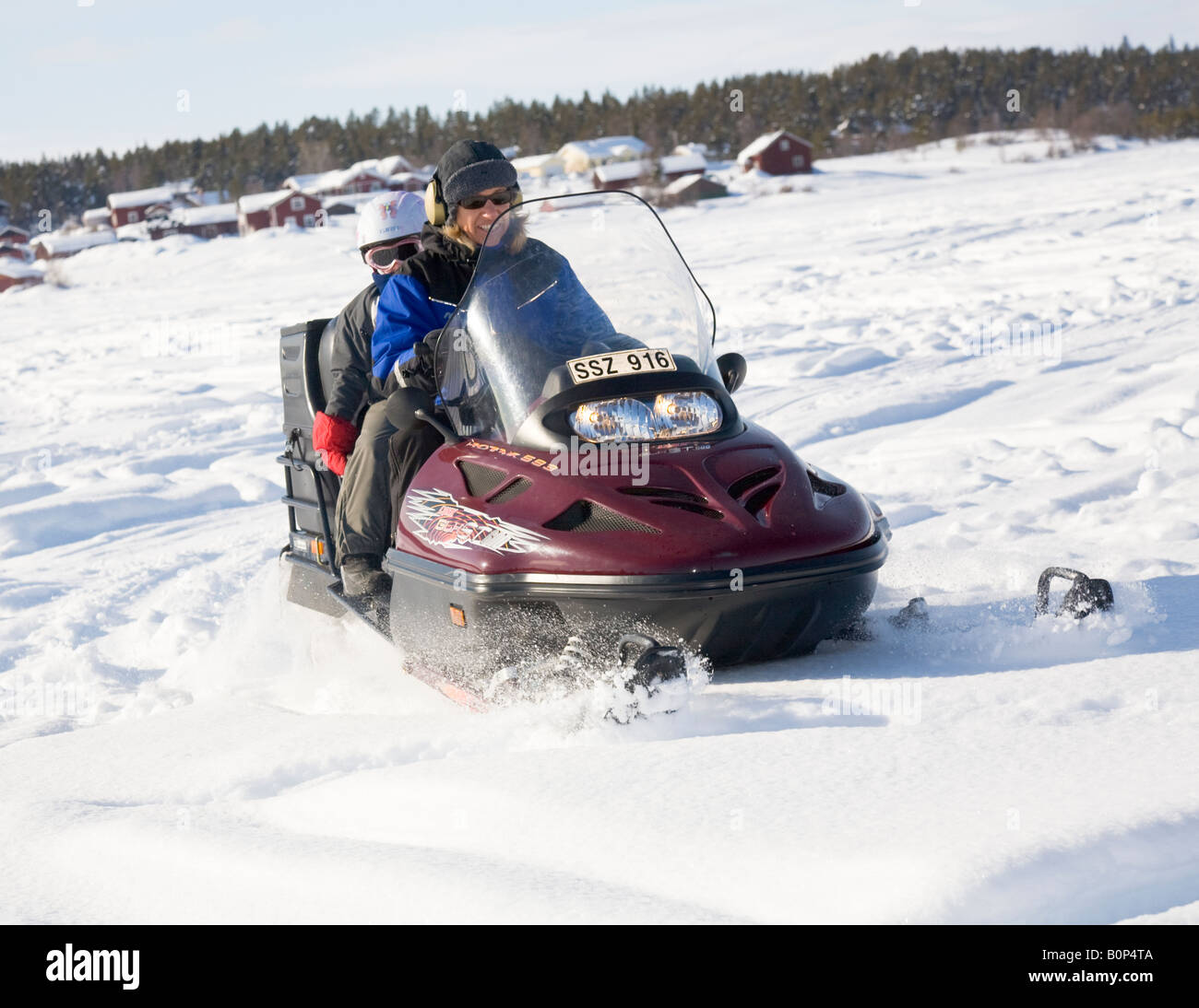 A woman in her fourties rides a Lynx snowmobile in snowy Lapland, a six ...