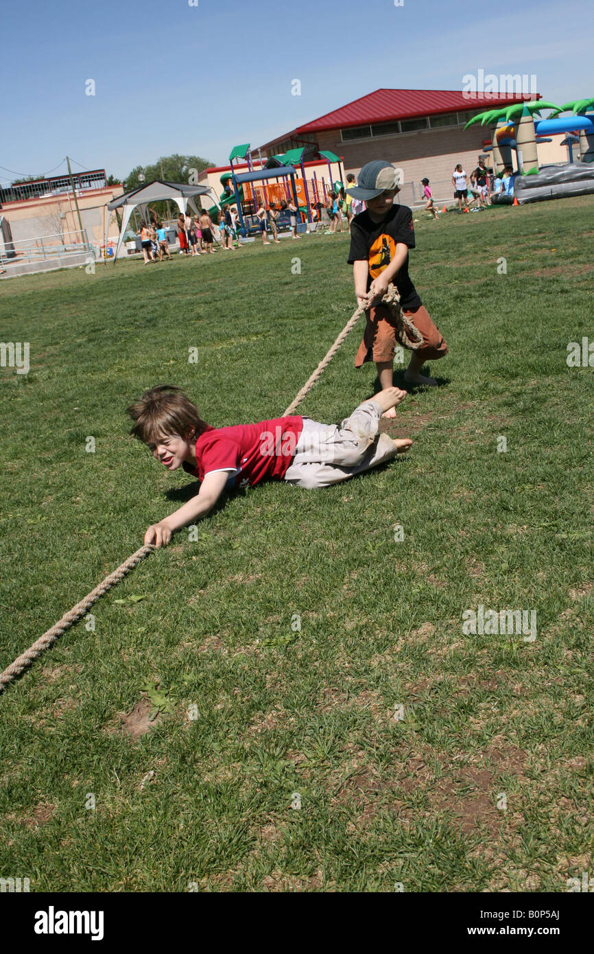 children pulling rope during tug of war game at school field day fun ...
