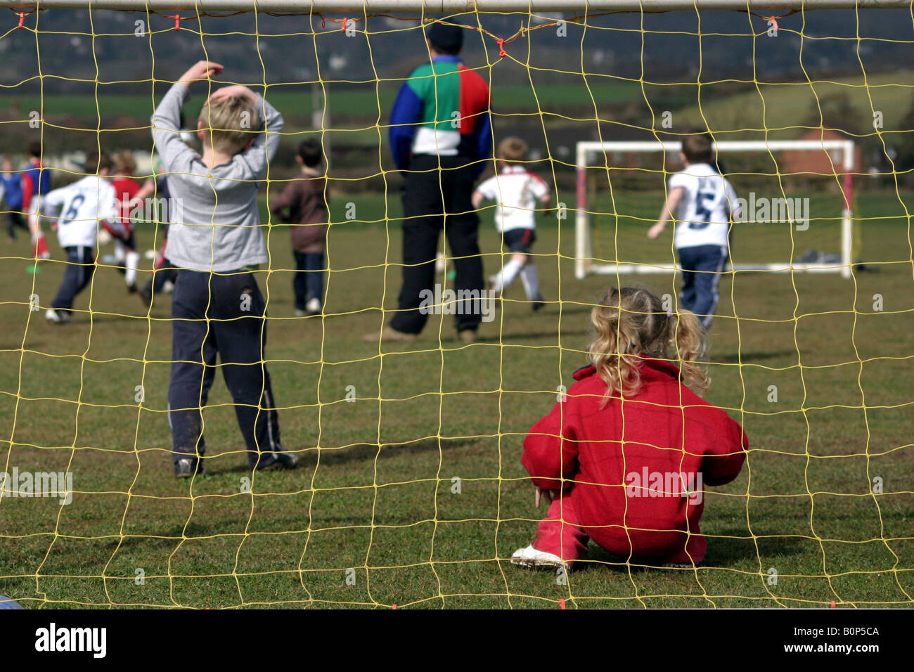 little girl playing in goal during a football match between children ...