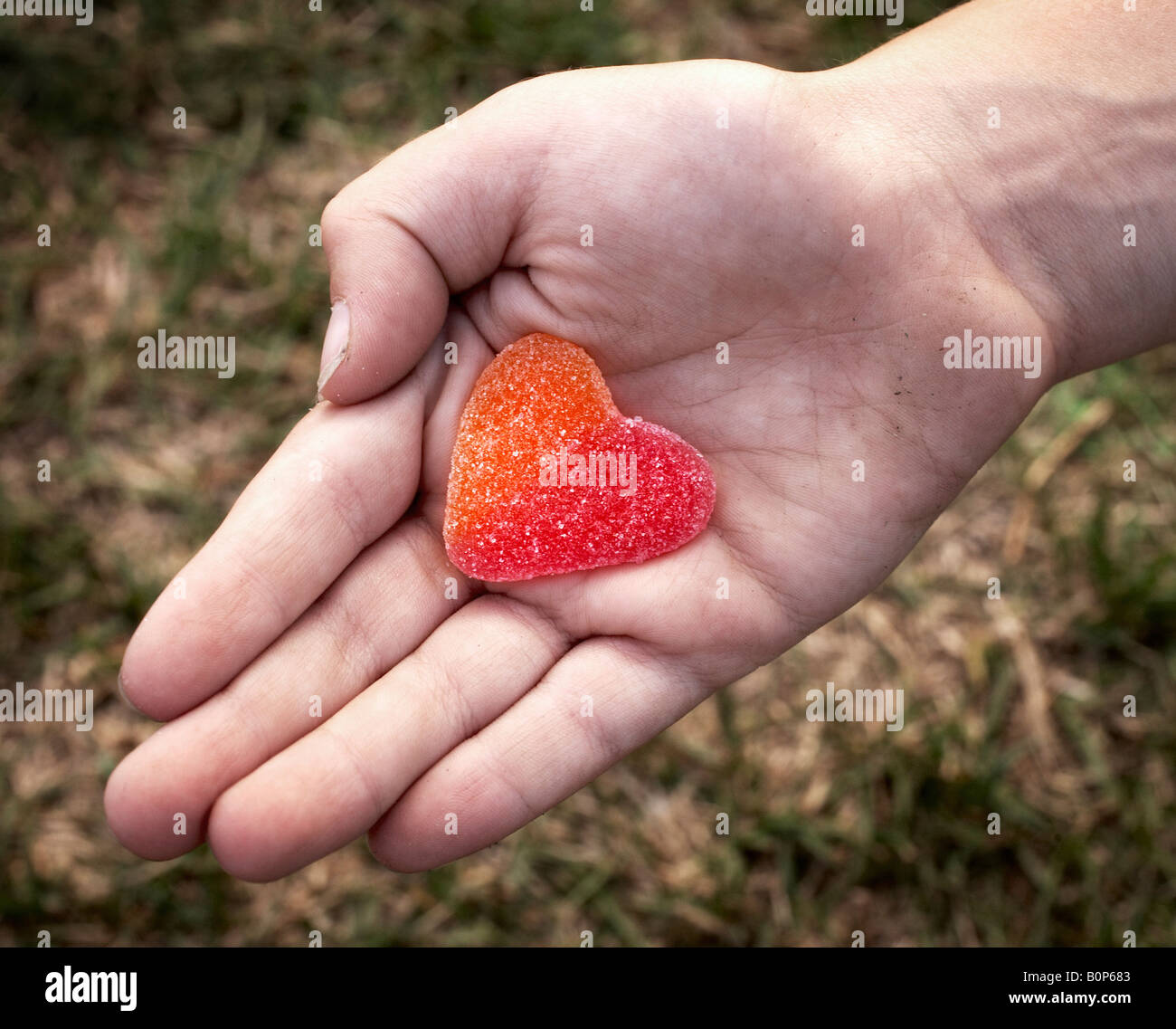 hand holding heart shaped sweet in his hand Stock Photo - Alamy