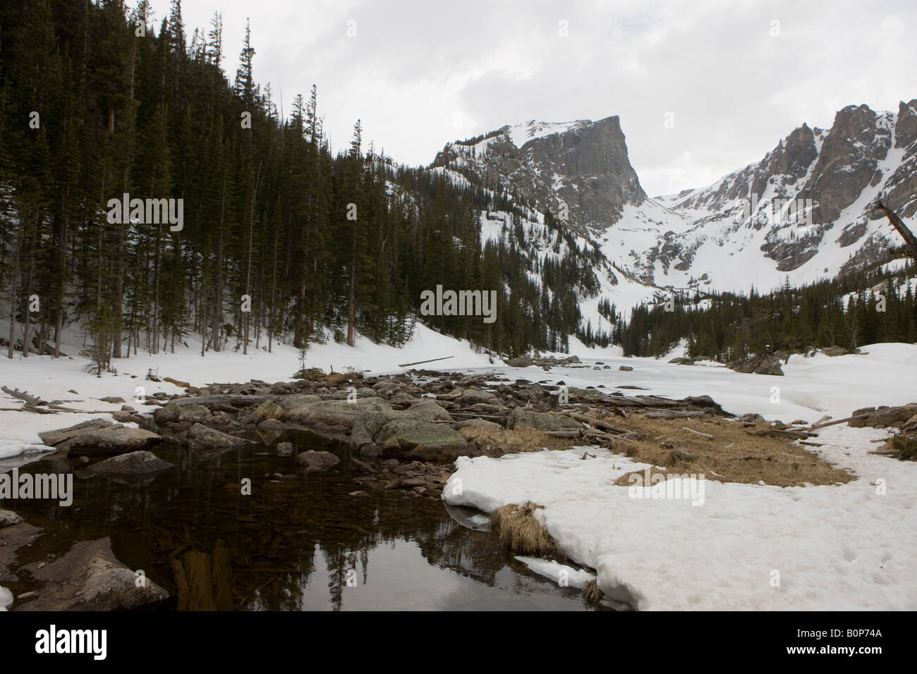 Snow and ice cover a frozen Dream Lake and surrounding peaks in the ...