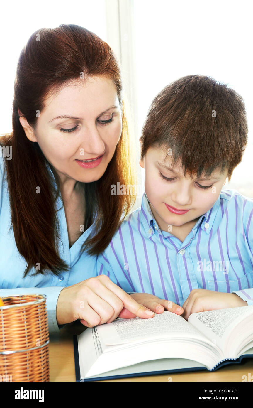 Teacher or tutor helping school boy to study Stock Photo - Alamy
