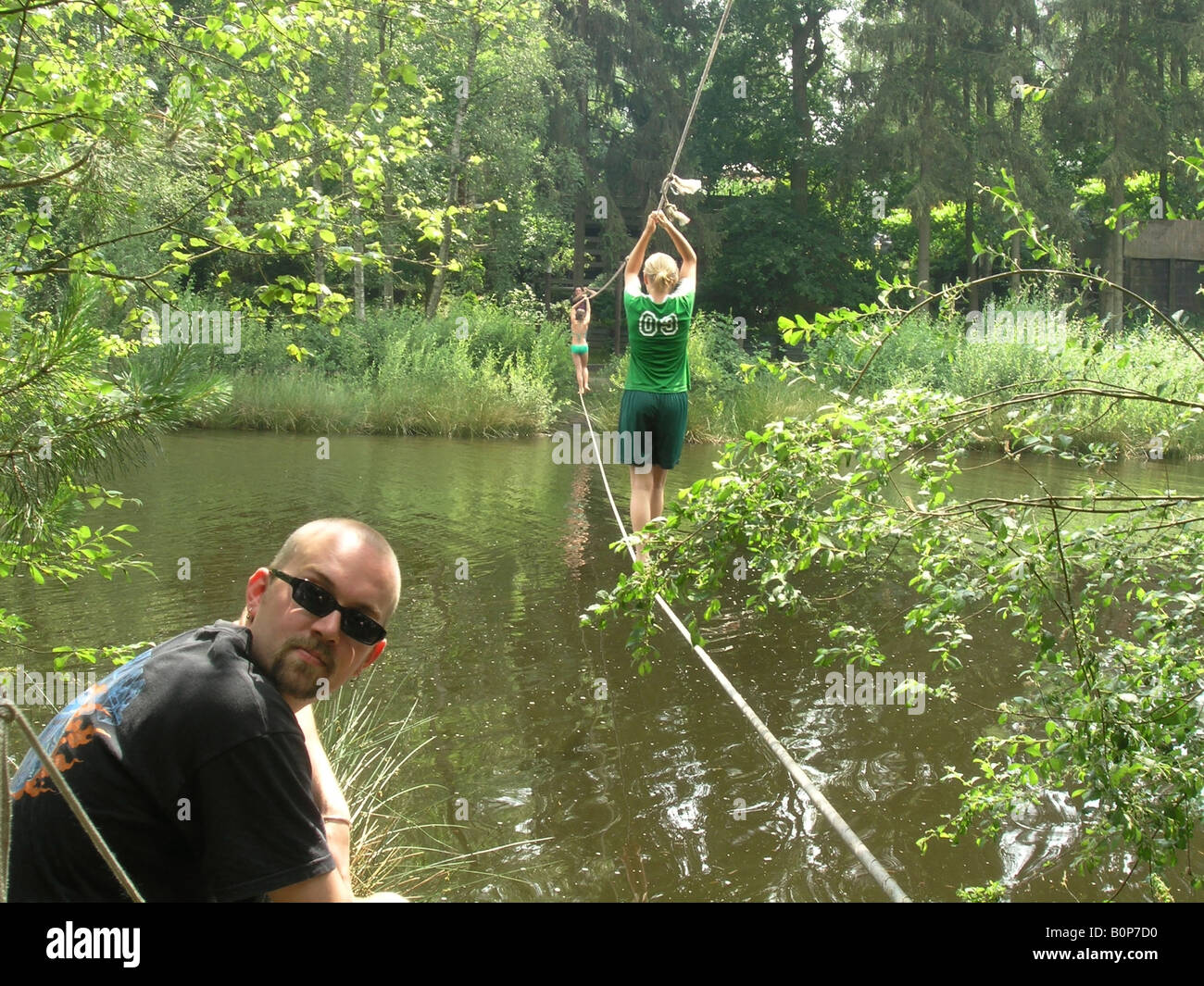 student crossing river by rope ladder Stock Photo - Alamy