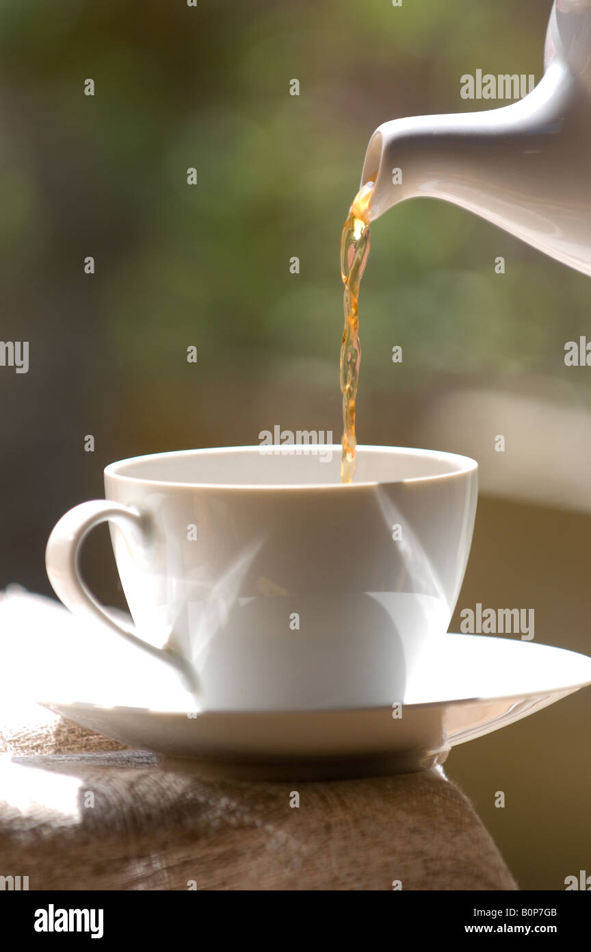 Pouring tea in the garden Stock Photo - Alamy