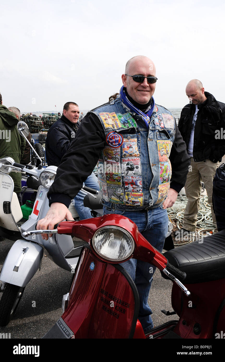 view of person wearing denim jacket covered in patches from scooter ...