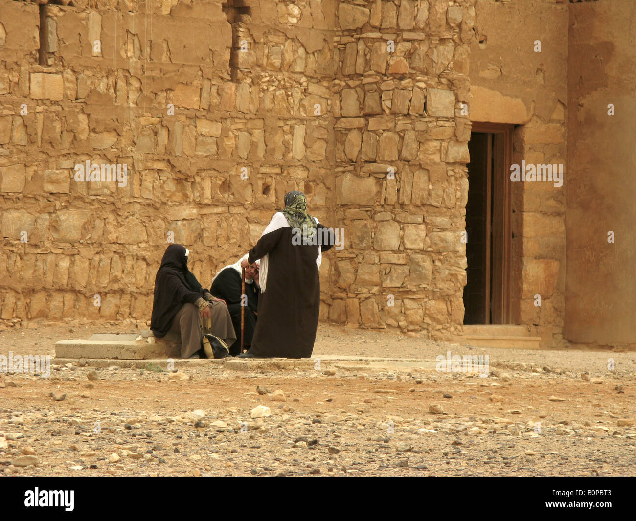 Muslim women sitting just outside the Qasr al Harana sand castle in ...