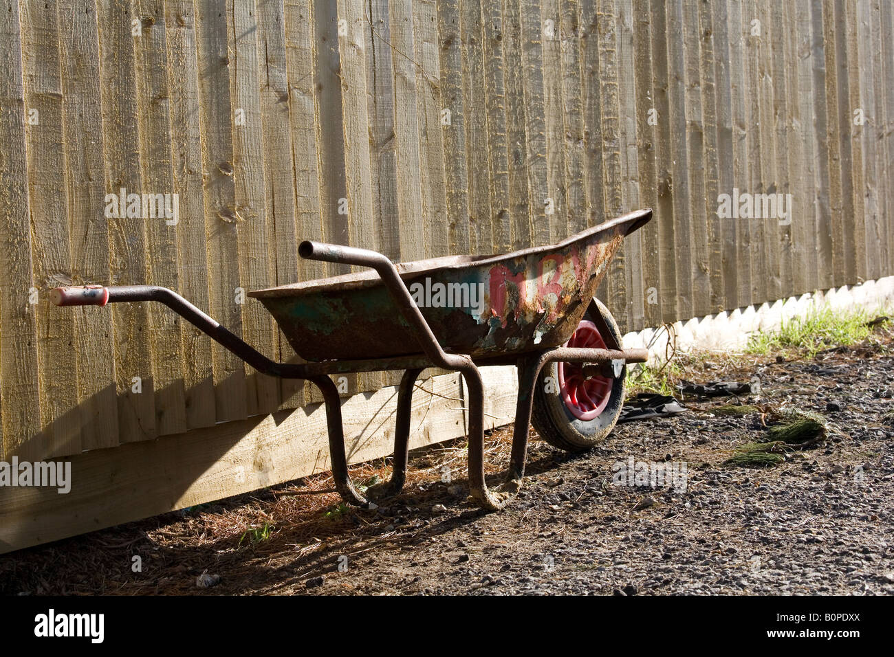 Old rusty wheelbarrow propped against fence Sandbanks Dorset UK Stock ...