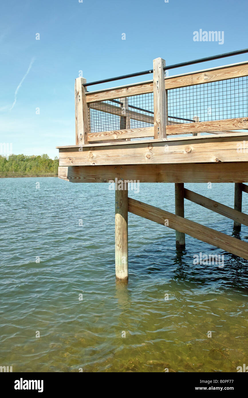 Vertical photo of a wooden fishing dock on a small inland lake or pond ...