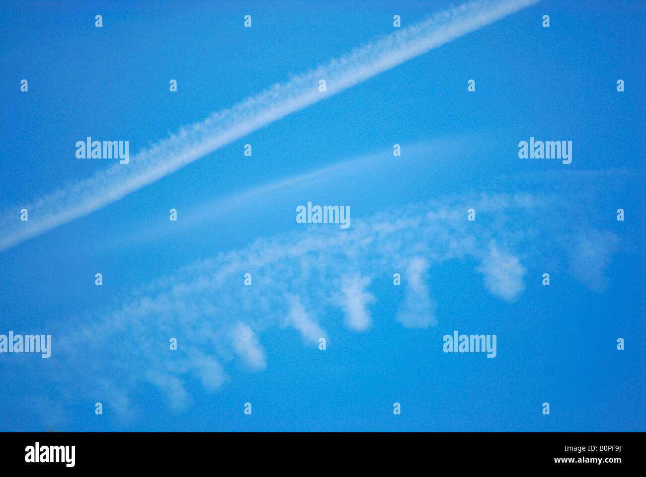 vapor trails or chemtrails from jets in sky often forming grid or ...