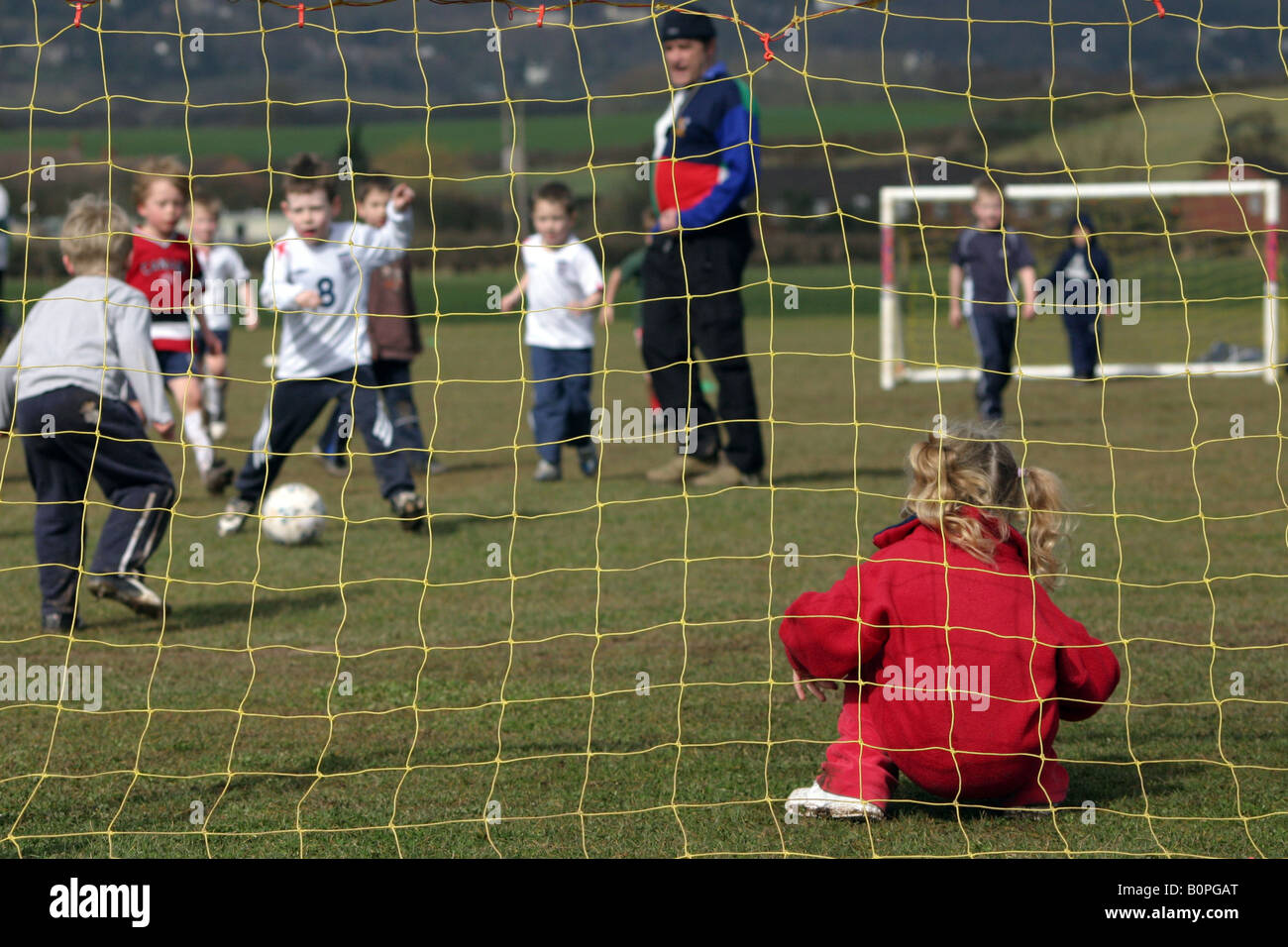 little girl playing in goal during a football match between children ...