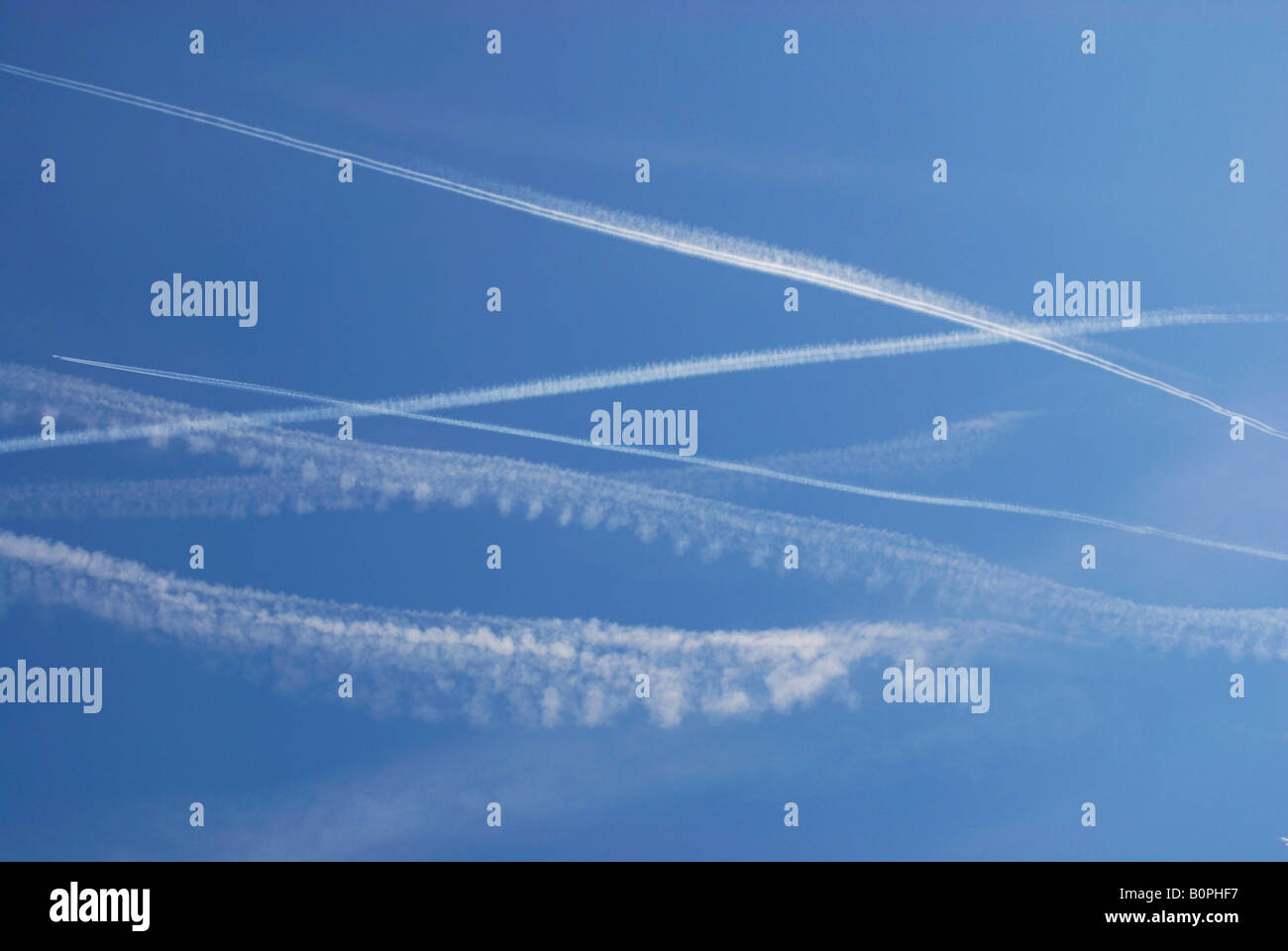 vapor trails or chemtrails from jets in sky often forming grid or ...