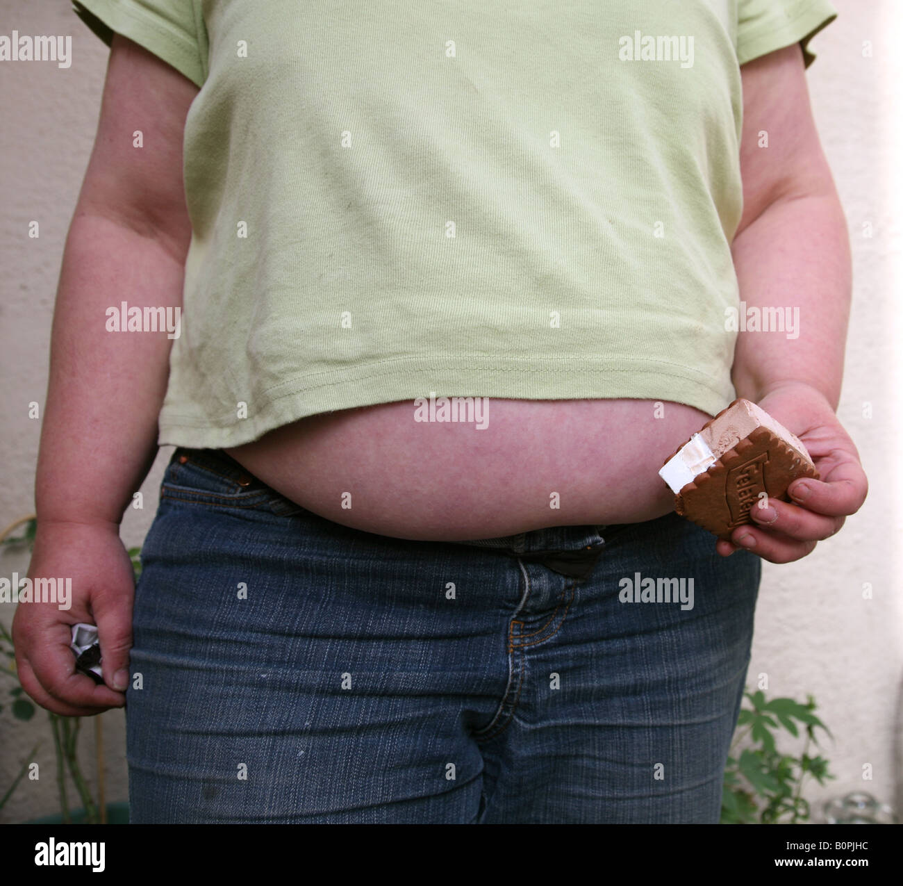 A very overweight female eating a chocolate ice cream bar morbidly ...