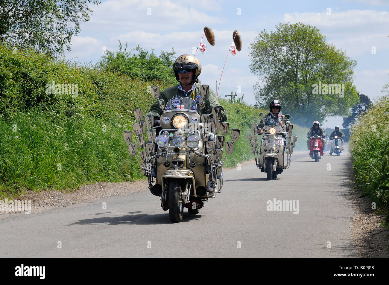 Scooterists riding along a country road Stock Photo - Alamy