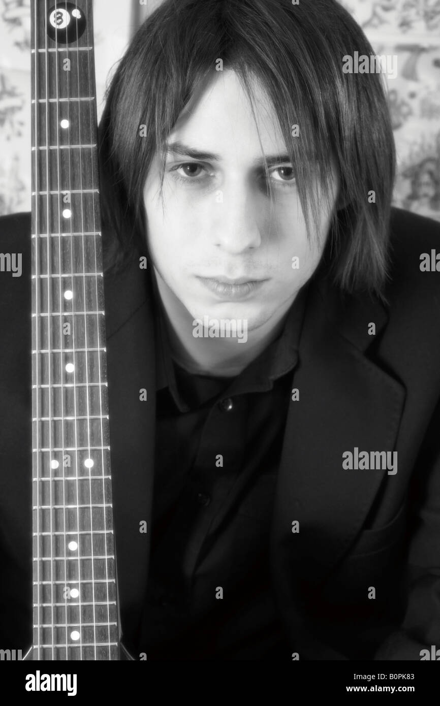 Young man with strong gaze playing guitar in a tattoo parlour Stock ...