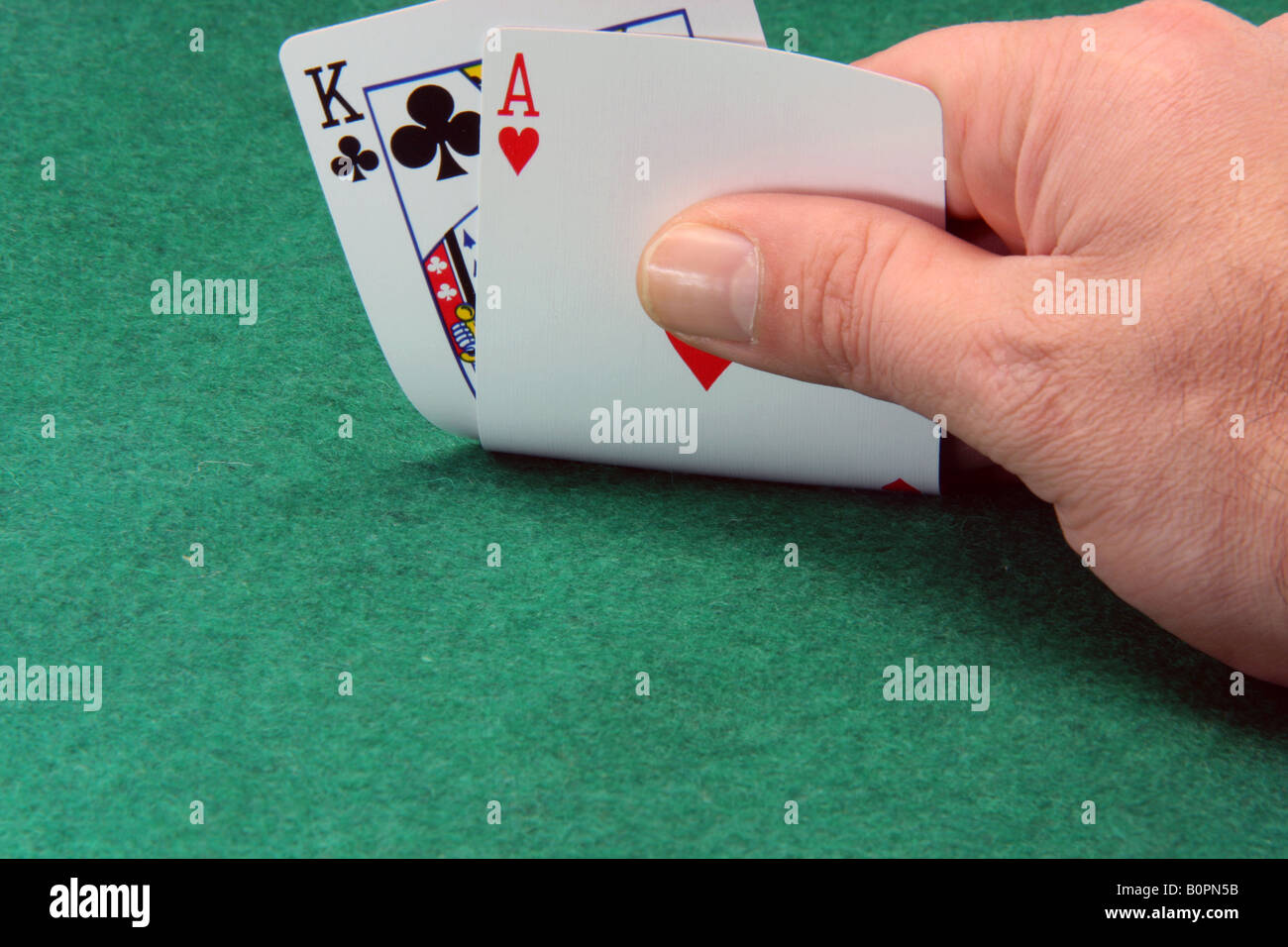 hand holding ace and king closeup on green felt background Stock Photo ...