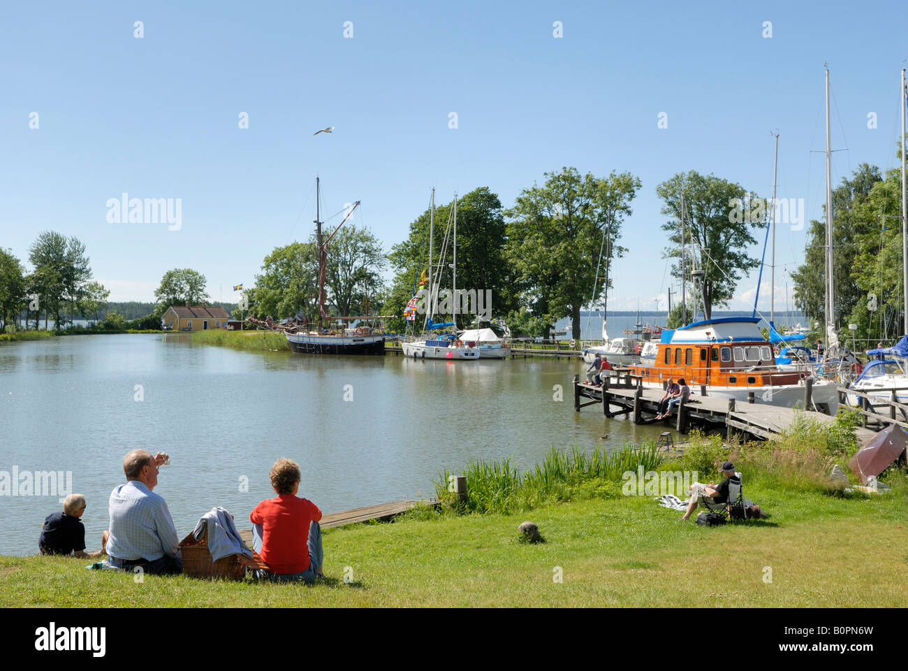 People sitting in the grass at a marina of the Gota Canal Sjotrop ...