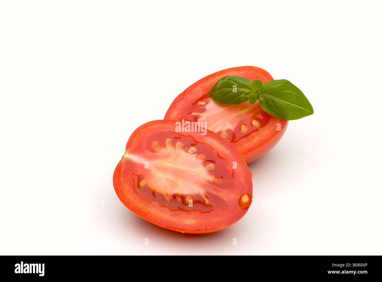 Ripe Roma tomato sliced in half with sweet basil herb, isolated Stock ...