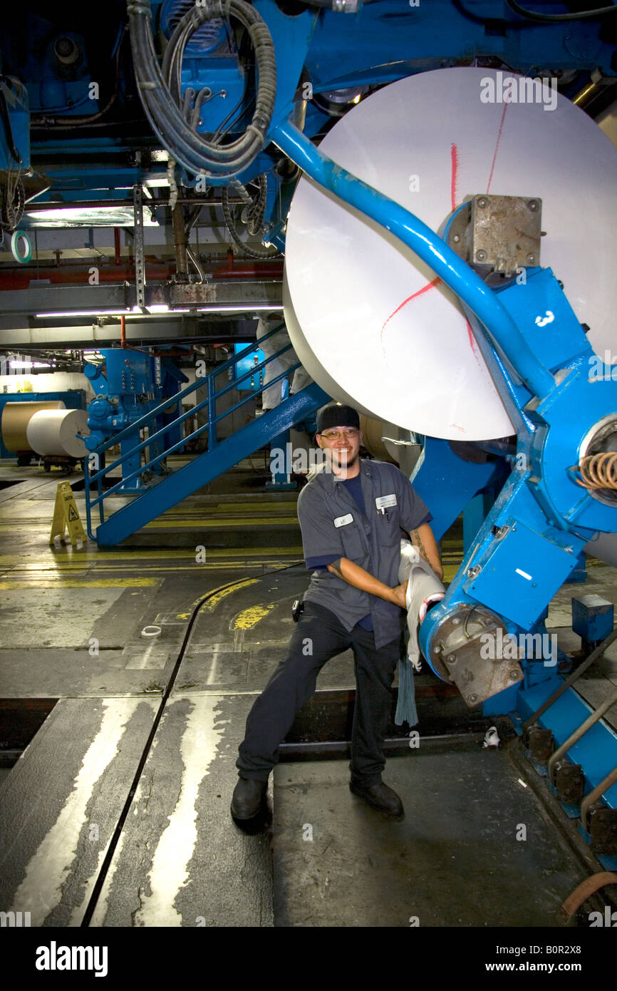 Pressman Loading A Large Roll Of Paper On To A Rotary Printing Press pressman-loading-a-large-roll-of-paper-on-to-a-rotary-printing-press