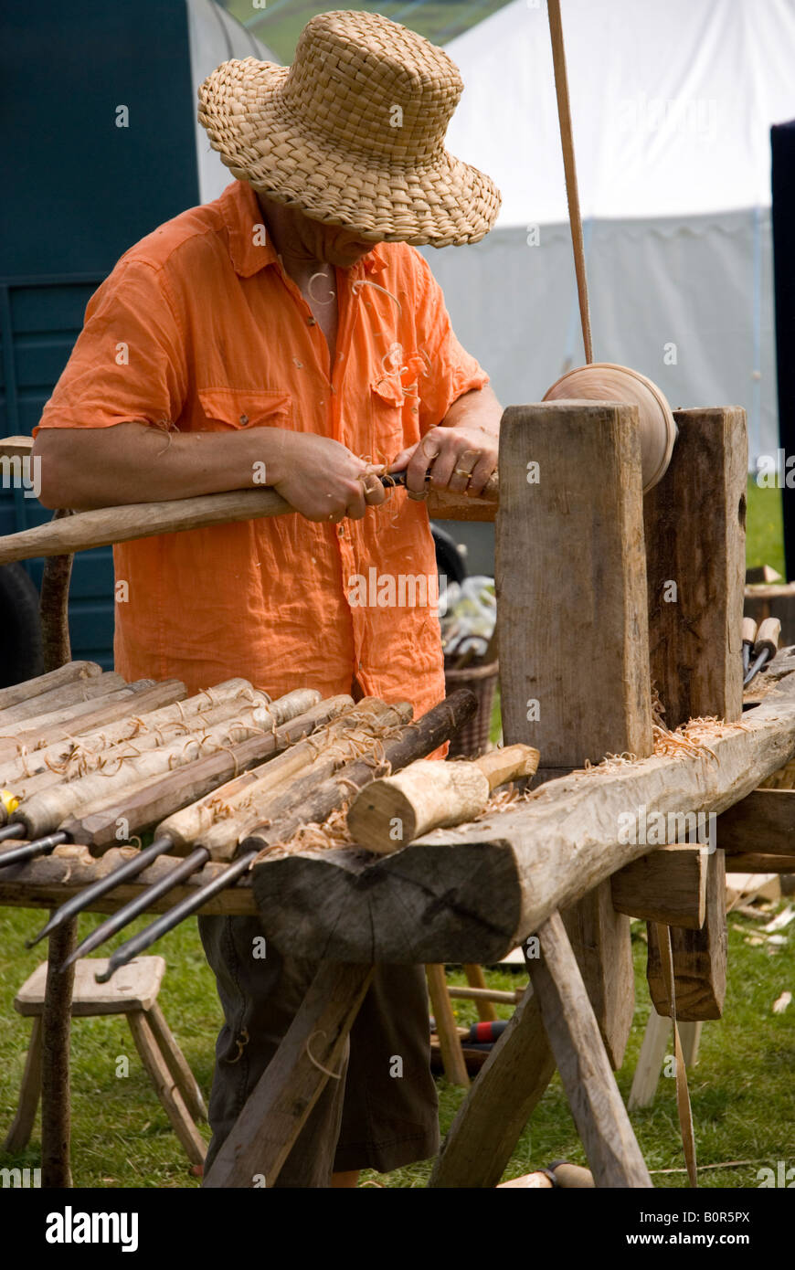 A crafsman demonstrates the use of a traditonal foot powered wood lathe ...